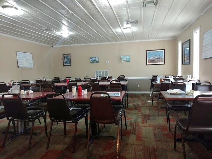 Simple tables, practical chairs, and landscape paintings create that perfect small-town diner atmosphere where conversations flow as freely as the coffee refills.