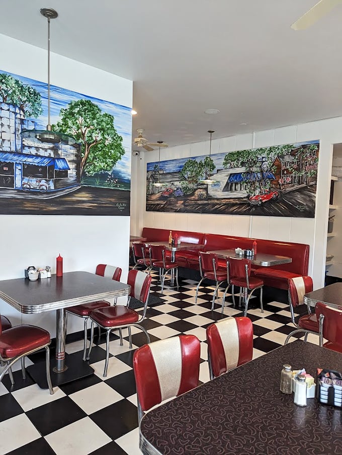 Classic Americana comes alive inside with checkerboard floors and cherry-red vinyl booths. Those murals aren't just decoration—they're visual appetizers for the feast to come.
