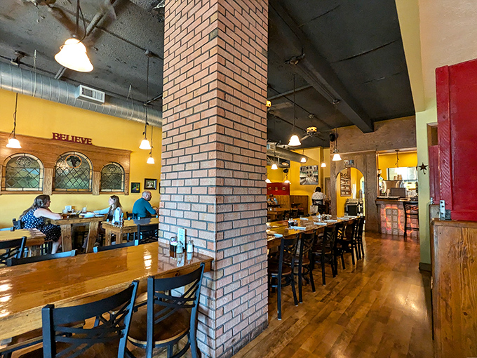 Exposed brick columns and sunny yellow walls create that rare atmosphere where you could propose marriage or debate sports with equal comfort.