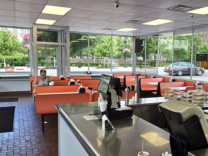 Bright orange booths and abundant natural light create the perfect backdrop for burger bliss—no Instagram filter required.