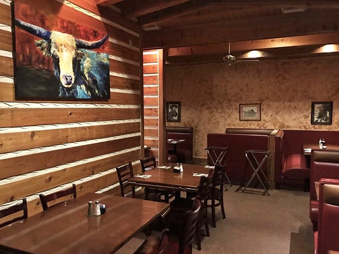 Log cabin walls meet cozy booths in this dining room where that steer painting isn't judging your order—he's jealous of what's about to land on your plate.