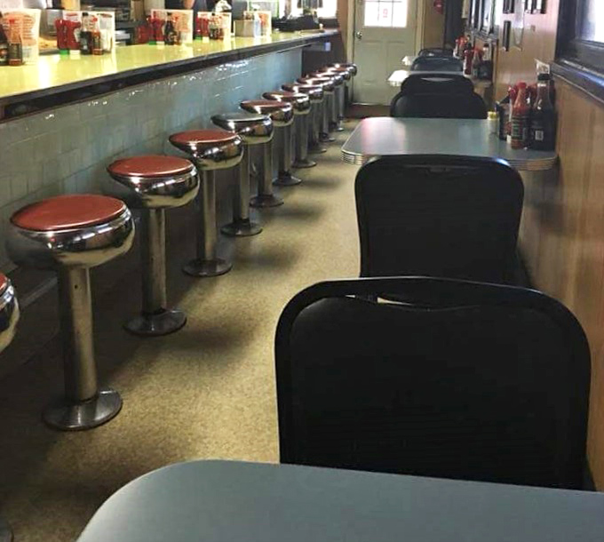 Red counter stools await their next occupants, standing sentinel like loyal soldiers in a delicious battle against hunger.