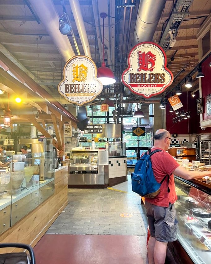 Suspended signs guide hungry market-goers to their sweet salvation. The industrial ceiling pipes above somehow add to the charm of this bustling bakery space.