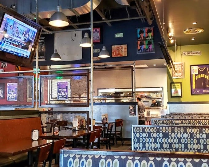 Industrial chic meets comfort food haven. The exposed ceiling, pop art walls, and cozy booths create the perfect backdrop for serious burger contemplation.