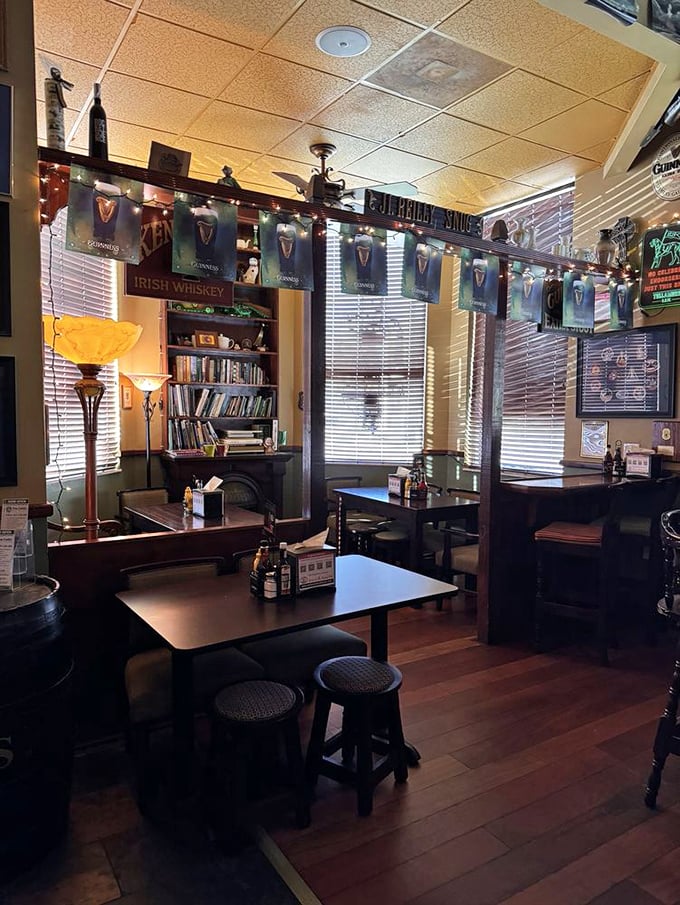 Guinness banners flutter above cozy wooden booths, where the book exchange shelf proves that good literature pairs perfectly with good beer.