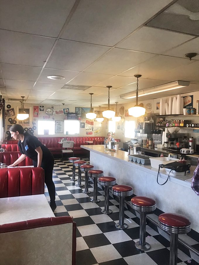 Red vinyl booths, chrome counter stools, and that iconic checkered floor—this isn't retro-themed, it's authentically preserved Americana.