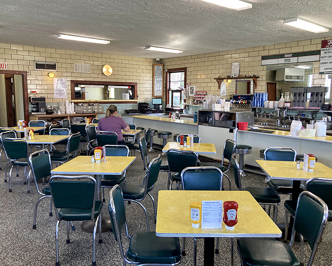 Yellow Formica tables and mint-green chairs create the perfect backdrop for ice cream adventures—a diner aesthetic that's not retro by design, but authentic by survival.