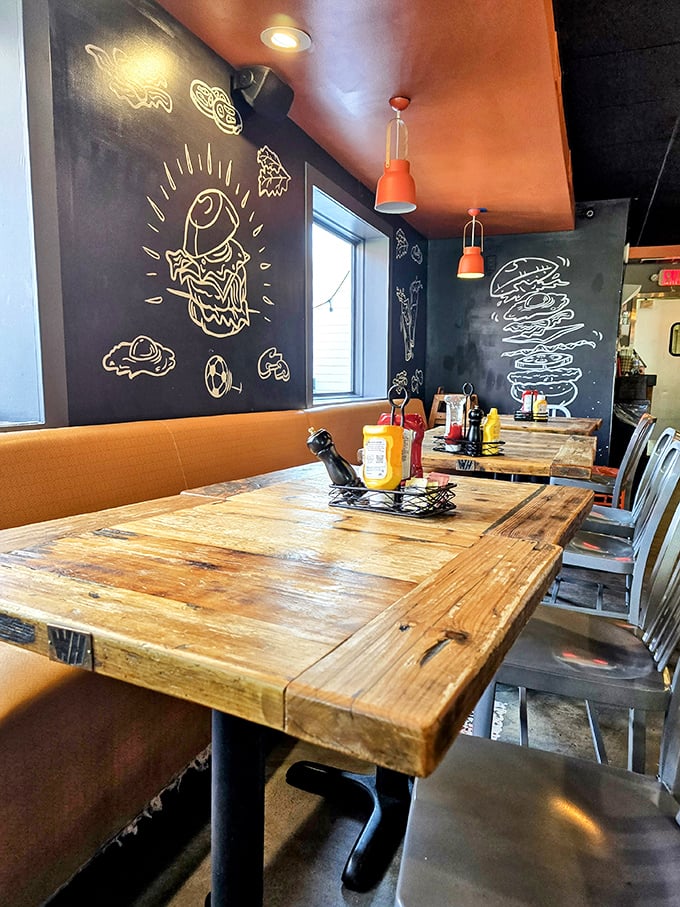 Rustic wooden tables meet playful chalk art in a dining room that feels like the coolest friend's kitchen—if that friend were a burger genius.