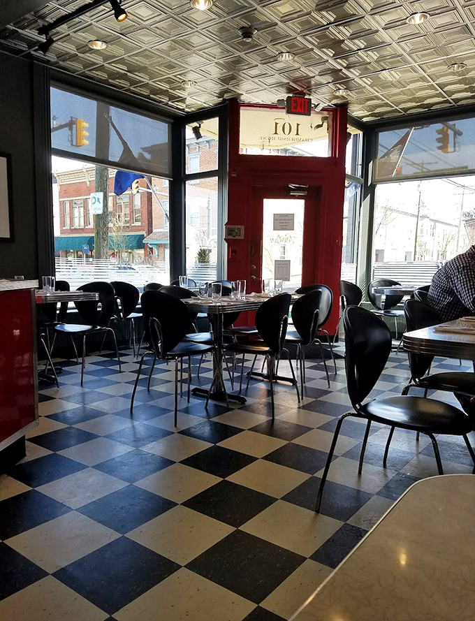 Classic black and white checkered floors meet vintage ceiling tiles in this dining room that feels both nostalgic and perfectly modern.