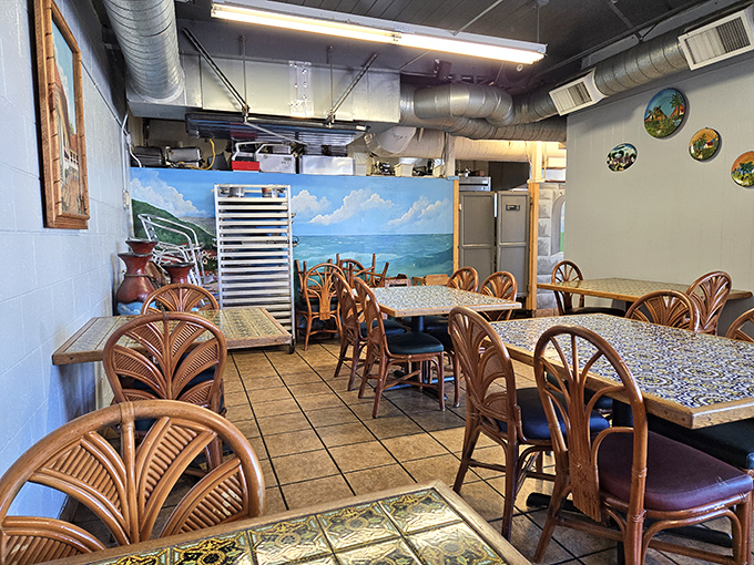 Rattan chairs and colorful tile tables create a welcoming vibe. The beach mural whispers "vacation" while the exposed ductwork keeps it real—just like the food.