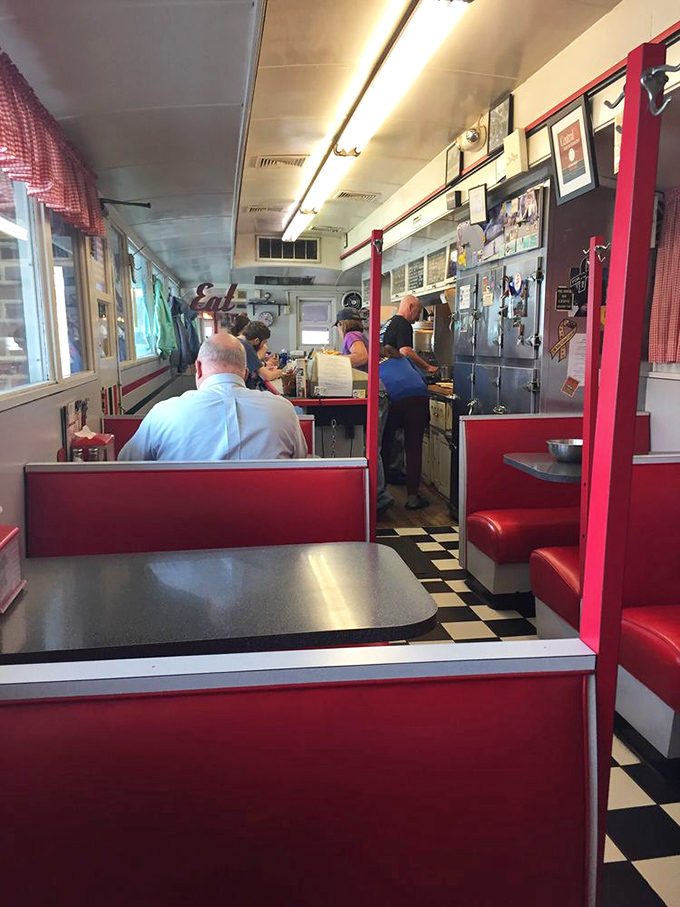 Classic diner geometry: red vinyl booths, checkered floor, and a counter where regulars have been solving the world's problems over coffee for decades.