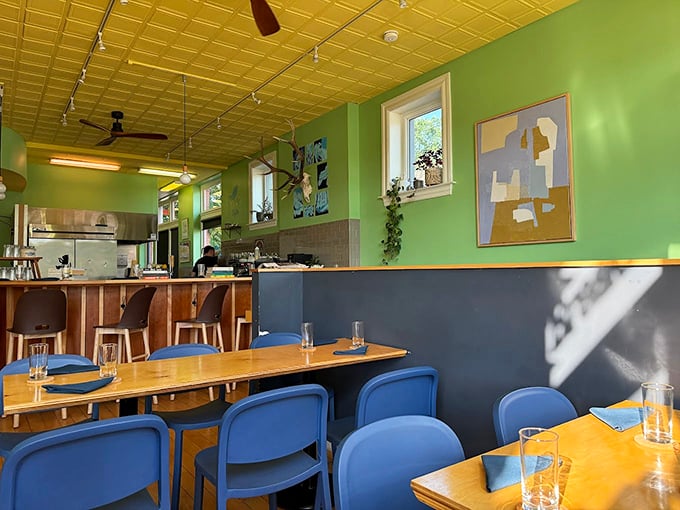 The mint-green walls and blue chairs create a space that feels both trendy and timeless—like your coolest friend's apartment, if that friend could cook brilliantly.