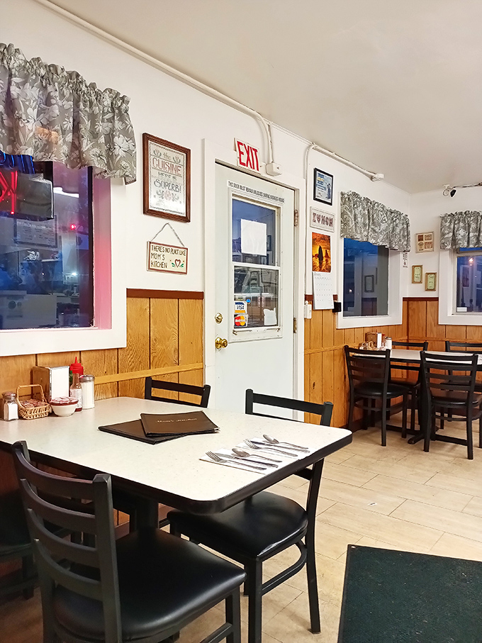 Classic diner charm at its finest—wood paneling, simple tables, and those floral curtains your grandmother would absolutely approve of.