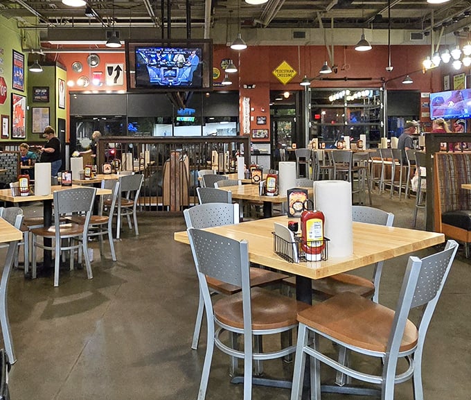 Industrial-chic meets comfort in this dining room where wooden tables await their delicious burdens and TVs promise sports with your sammies.