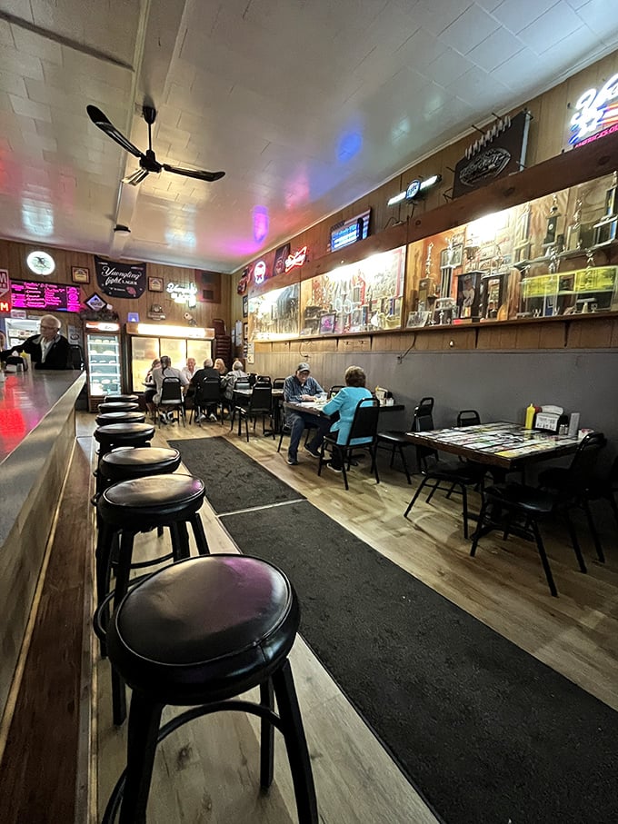 Inside, wood paneling and neon signs create the perfect time capsule – where conversations flow as freely as the cold beer.