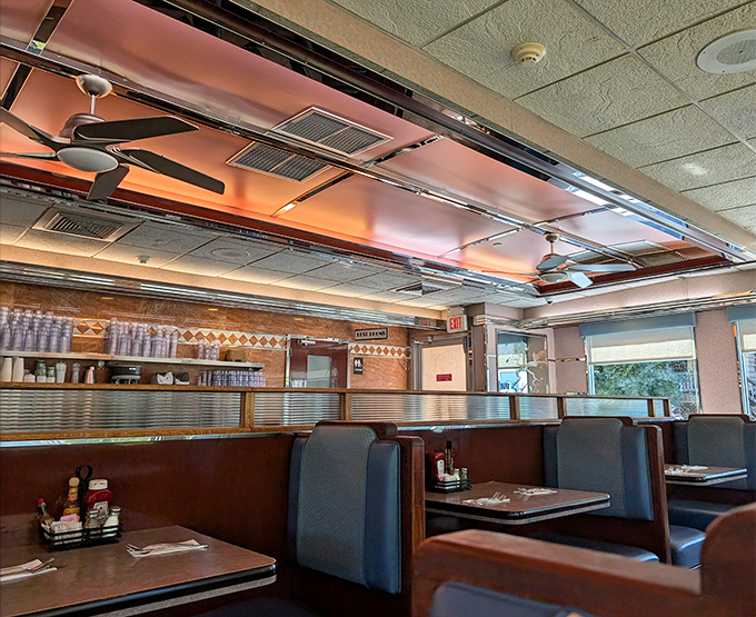 Classic blue vinyl booths and warm copper ceiling details create that timeless diner atmosphere where conversations flow as freely as the coffee.