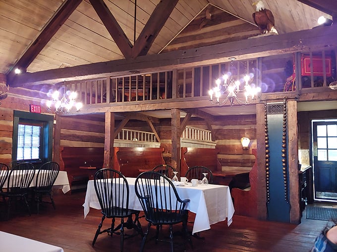 Inside, hand-hewn log walls and exposed beams create a time capsule where candlelit chandeliers illuminate dining spaces that George Washington would have found perfectly respectable.