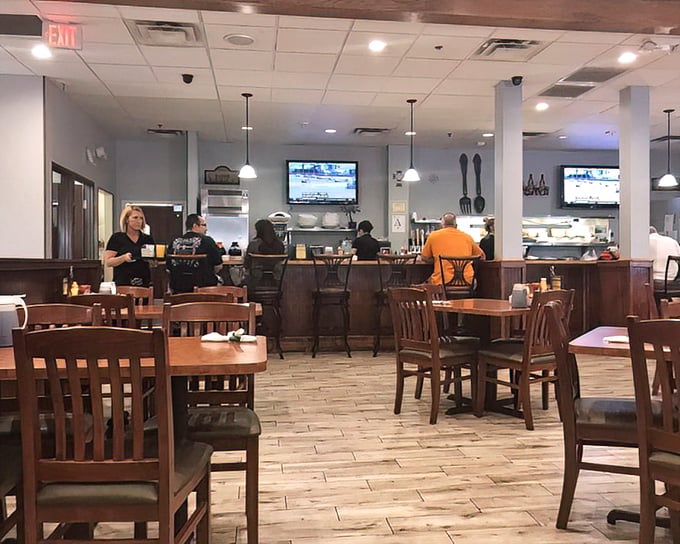 The dining room symphony: wooden chairs, pendant lights, and that unmistakable buzz of satisfied customers plotting their next menu conquest.