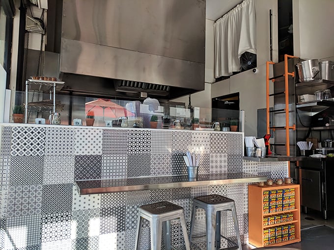 Geometric tile patterns meet industrial chic in this compact space where every square inch is dedicated to the art of deliciousness.