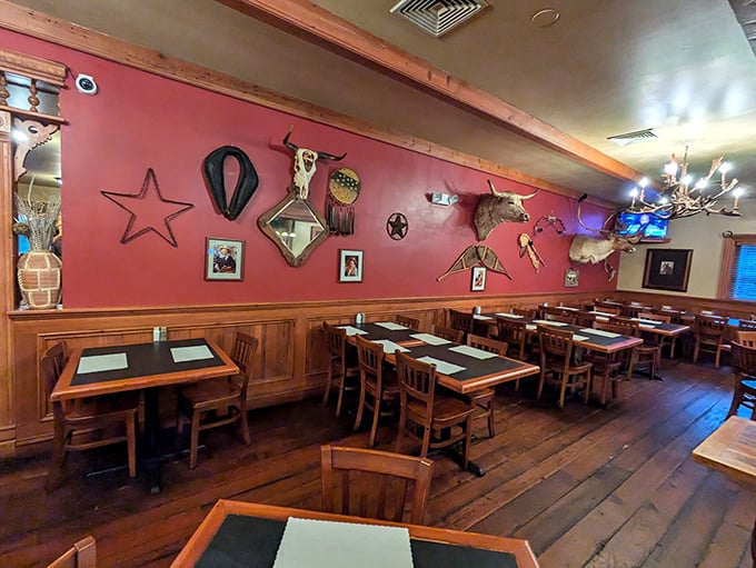 Red walls adorned with Western memorabilia create the perfect backdrop for serious steak consumption. No distractions, just anticipation.