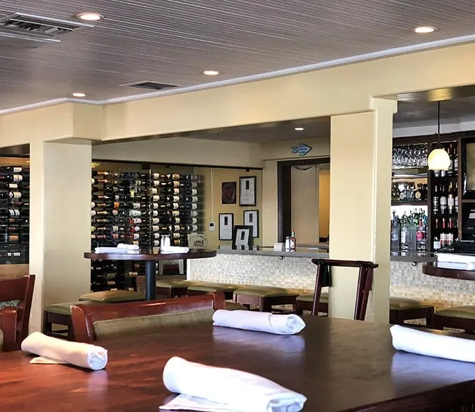 The elegant interior of Fish Hopper balances upscale dining with coastal comfort—where polished wood tables meet an impressive wine display that practically begs you to celebrate something.