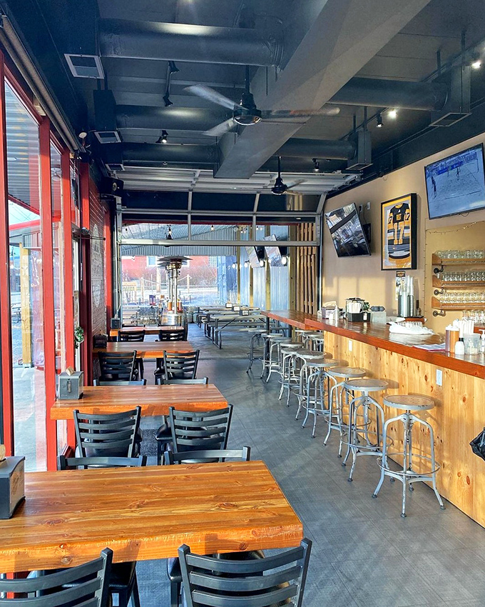 Modern meets comfort in this industrial-chic space where exposed ductwork somehow makes barbecue feel fancy without the fuss.