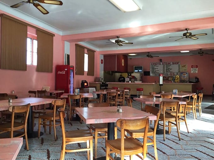 Pink walls, wooden chairs, and ceiling fans that haven't changed in decades—this isn't interior design, it's sandwich authenticity in its natural habitat.