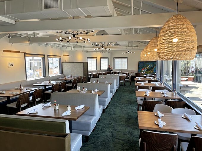 Wicker pendant lights cast a warm glow over white tablecloths and sea-green carpeting—nautical elegance without a single plastic lobster in sight.