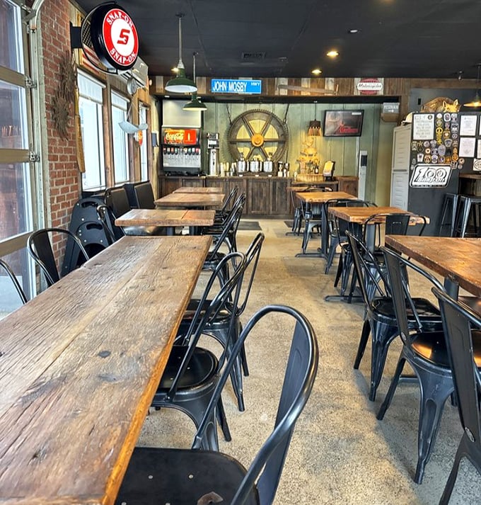 Rustic wooden tables and industrial metal chairs create the perfect setting for the serious business of barbecue consumption. That wagon wheel isn't just decor—it's a philosophy.