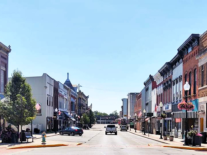 Main Street stretches invitingly ahead, its classic storefronts and hanging flower baskets creating that perfect small-town atmosphere Norman Rockwell would have rushed to paint.