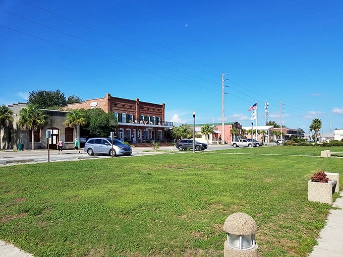 Historic brick buildings and palm trees line the streets, blending coastal charm with small-town warmth under bright Florida sunshine.