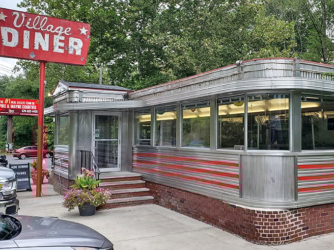 Village Diner's red trim pops against the silver exterior – like lipstick on a chrome-plated movie star from the golden age.