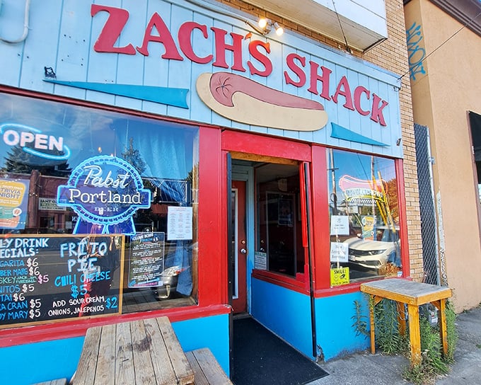 That vibrant blue exterior and vintage hot dog sign are like a beacon for hungry souls. The red door practically screams "come in and forget your diet!"