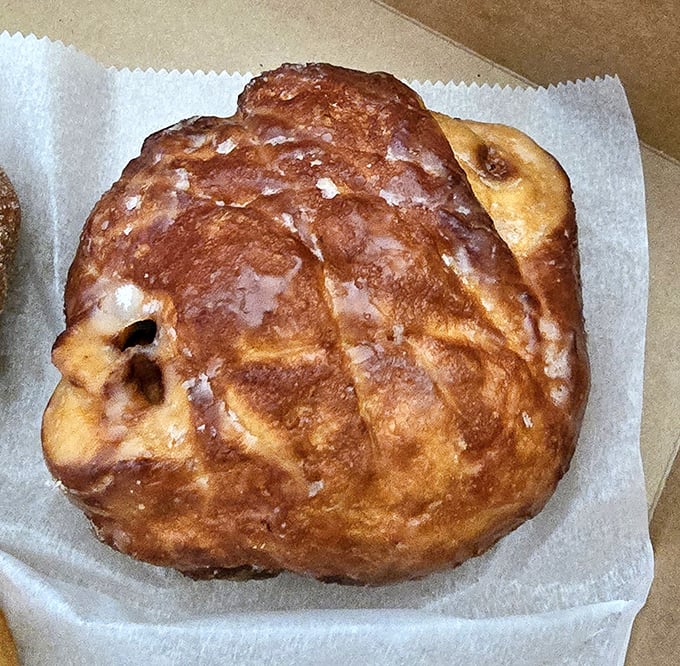 The legendary apple fritter in all its glazed glory. This isn't just fried dough – it's an architectural marvel of crispy edges, tender interior, and apple-cinnamon pockets that would make Frank Lloyd Wright jealous.