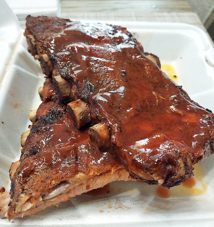 These ribs don't just fall off the bone—they practically leap into your mouth, glistening with that perfect lacquer of sauce and smoke.