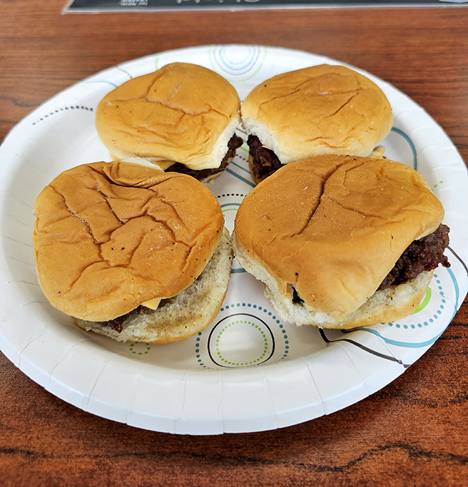 Four perfect sliders await their destiny on a paper plate. Small in stature but mighty in flavor—the burger equivalent of Danny DeVito.