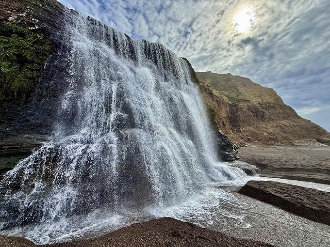 Up close, the waterfall reveals its true power – a thundering curtain of white noise and mist that drowns out everything but the moment.