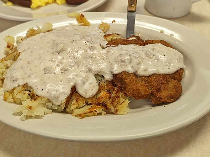 Behold the star attraction: country fried steak swimming in pepper gravy that could make a vegetarian question their life choices. This isn't just food—it's edible therapy.