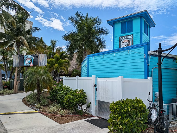 That vibrant turquoise building isn't just eye-catching—it's Dockside Waterfront Grill, where seafood tastes fresher when you can see the water it came from.