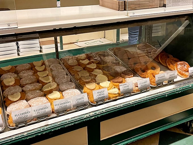 A rainbow of filled donuts awaits, each labeled with the promise of fruit-filled joy. Choosing just one feels like Sophie's Choice: The Pastry Edition.