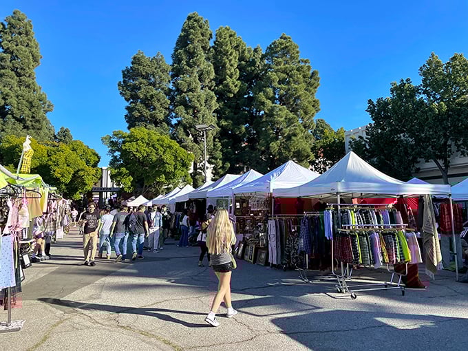 A classic LA scene: shoppers weaving between white canopies while towering pines provide patches of shade – Mother Nature's air conditioning for determined deal-finders.