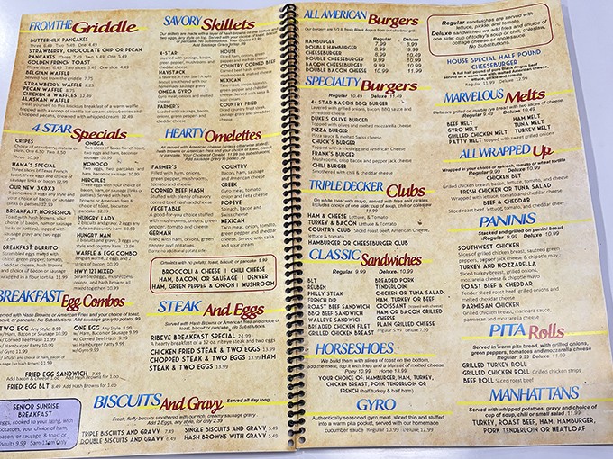 This spiral-bound menu isn't just a list of options—it's a roadmap to comfort food paradise with "Hearty Omelettes" that deserve their own zip code.