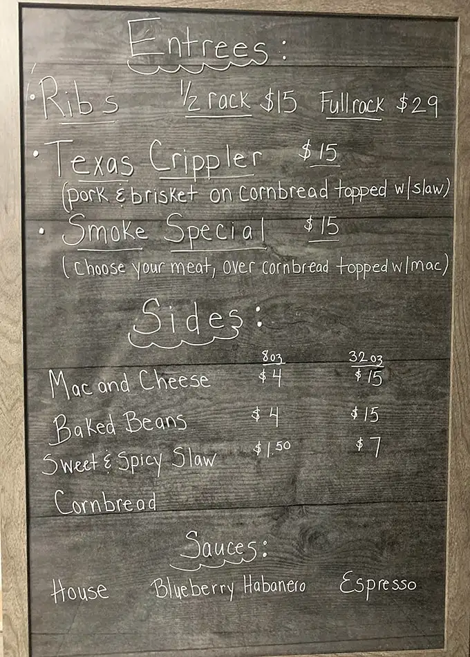 The chalkboard menu speaks volumes: no fancy fonts needed when your Texas Crippler and Smoke Special do all the talking.