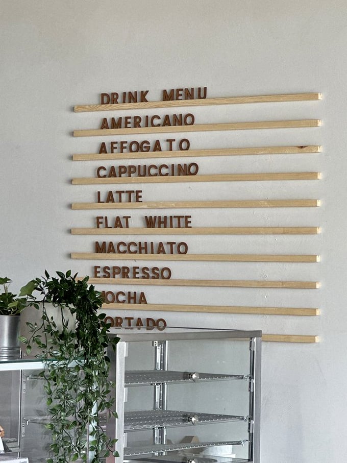 Coffee options lined up like delicious soldiers ready for duty. The wooden menu board is both rustic and sophisticated—just like the beverages it advertises.
