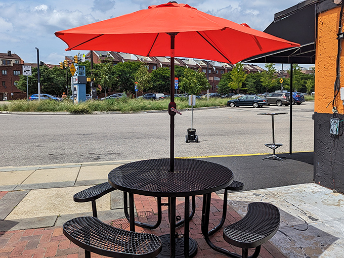 Al fresco dining with a bright red umbrella—nature's way of saying "the food here is so good, even the sun wants to hang around."