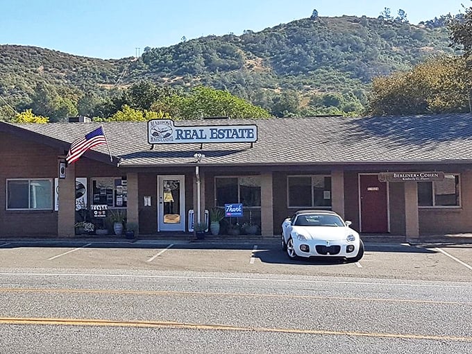 In coastal California, this real estate office might sell closets. In Mariposa, it sells dreams with actual square footage and yards where deer might become your gardening critics.
