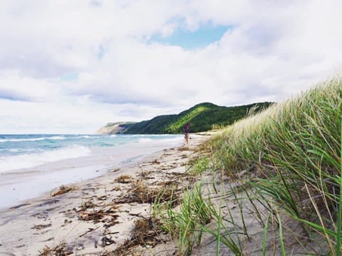 Some beaches collect people; this one collects moments. The dune grass whispers secrets while Lake Michigan performs its endless blue symphony.