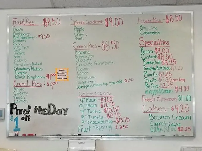 A whiteboard menu that reads like poetry to pie enthusiasts. The "Pie of the Day" discount is just the cherry on top.