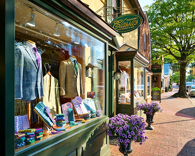 A clothing store display in Middleburg showcases colorful spring attire, perfectly framed by flowering planters.
