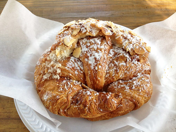 This almond croissant doesn't just flake – it practically performs a powdered sugar ballet on your shirt.